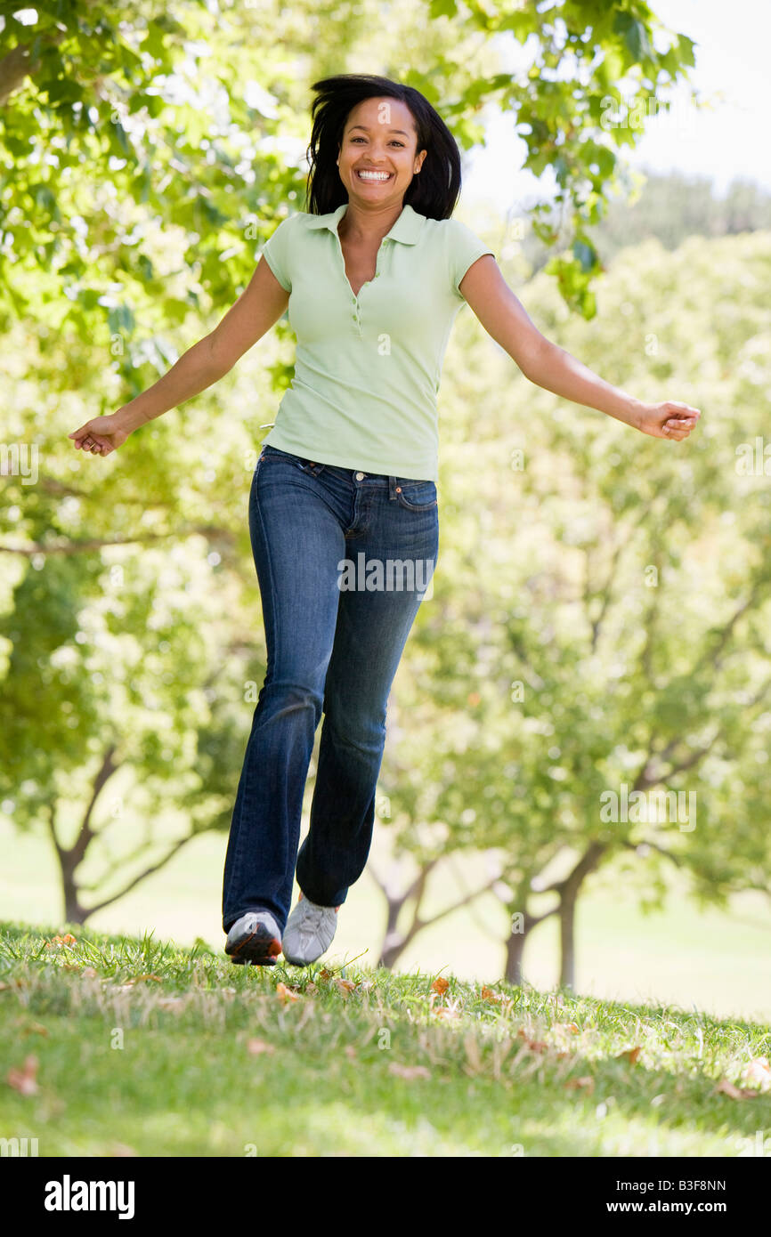 Woman running outdoors smiling Stock Photo - Alamy