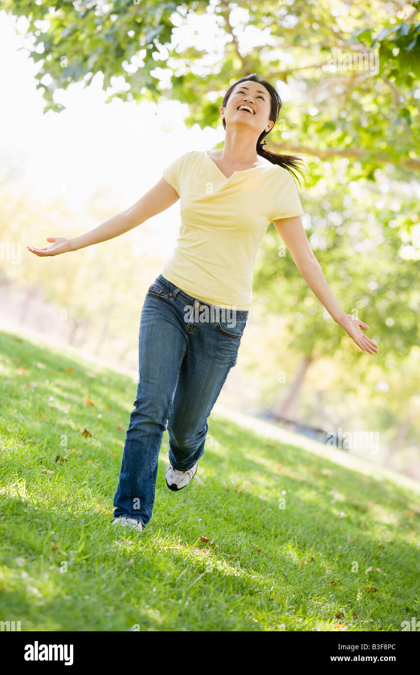 Woman running outdoors smiling Stock Photo - Alamy