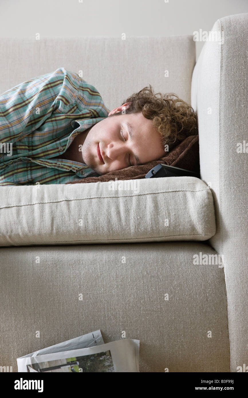 Man napping on sofa Stock Photo - Alamy