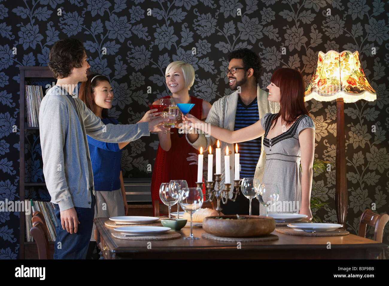 Group of people toasting standing by dining table Stock Photo - Alamy
