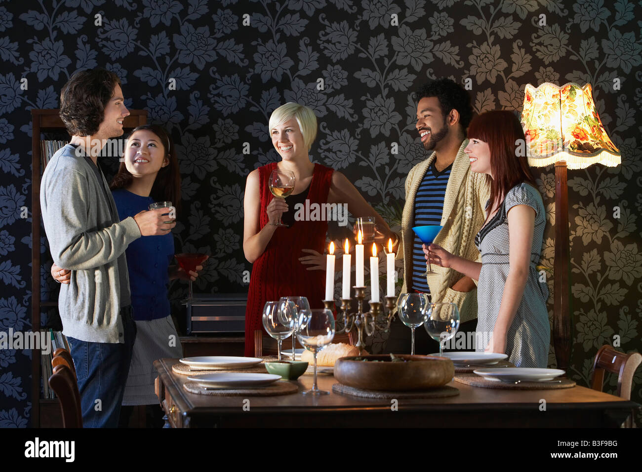 Group of people smiling, standing by dining table Stock Photo - Alamy