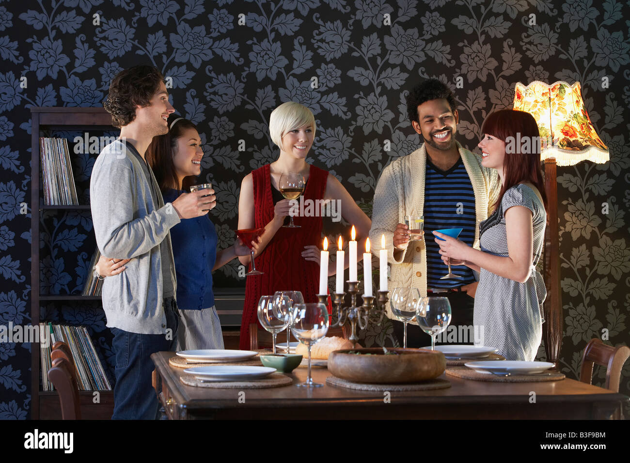 Group of people smiling, standing by dining table Stock Photo - Alamy
