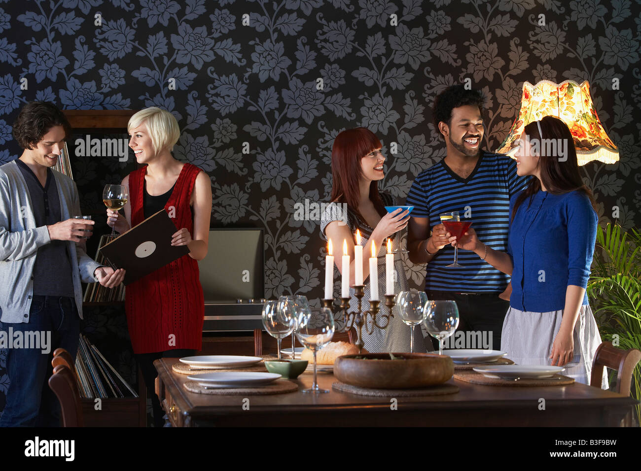 Group of people smiling, standing by dining table Stock Photo - Alamy