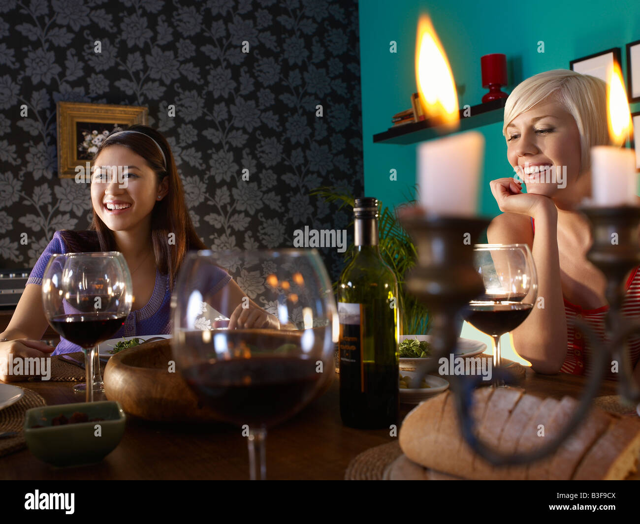 Two women sitting at dining table Stock Photo - Alamy