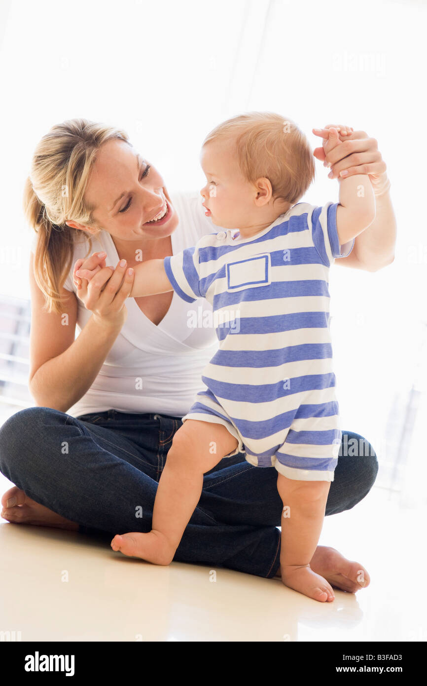 Woman helping baby stand hi-res stock photography and images - Alamy
