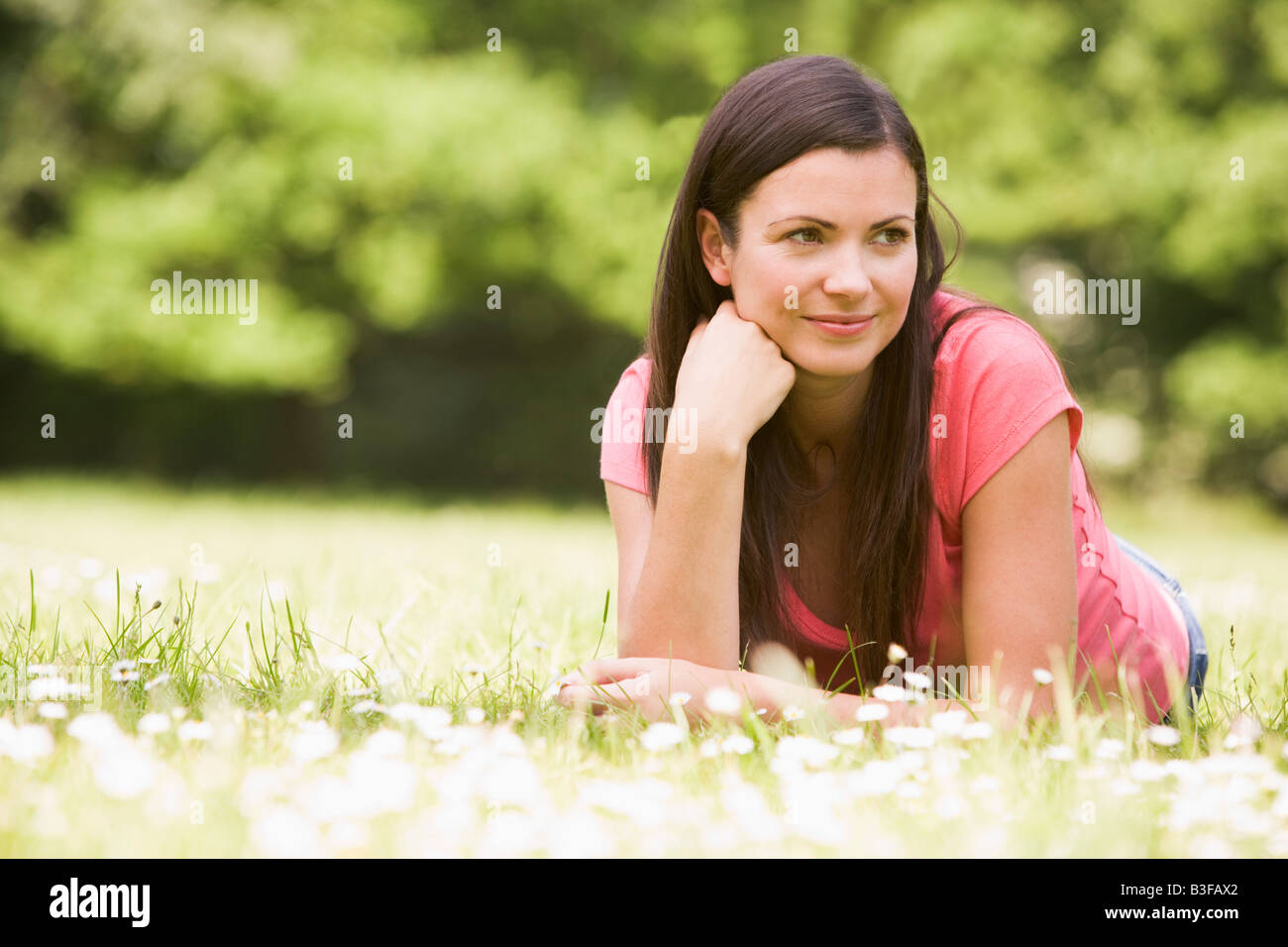 Woman lying outdoors smiling Stock Photo - Alamy