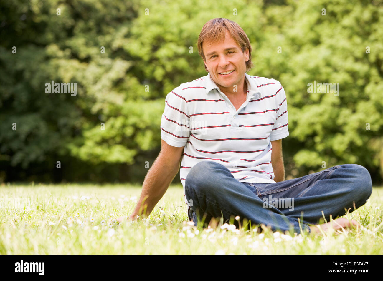 Man sitting outdoors smiling Stock Photo - Alamy
