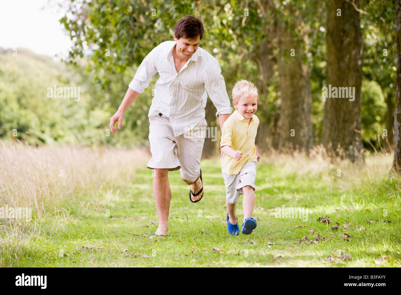 Father and son running on path smiling Stock Photo - Alamy