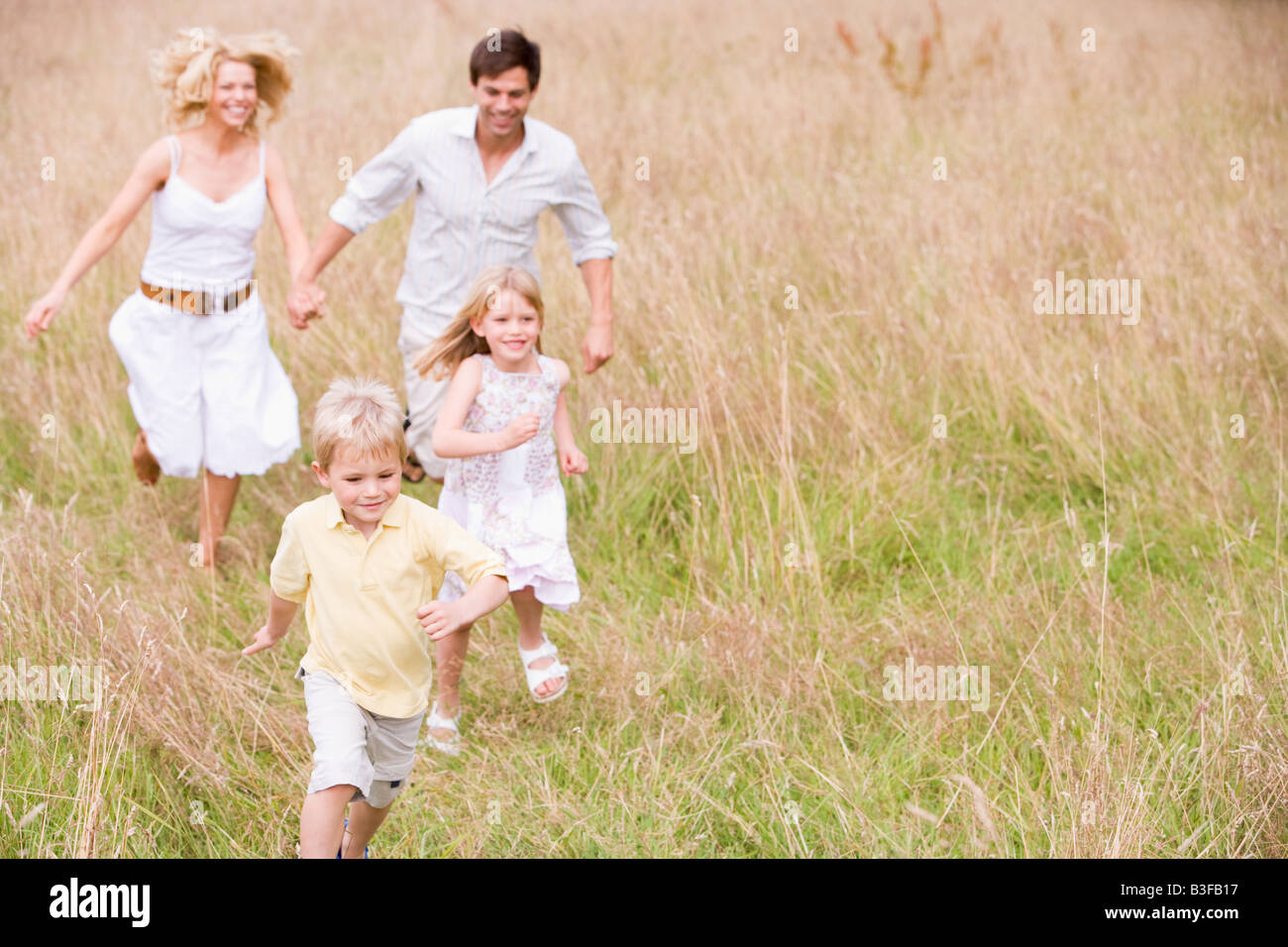 Family running outdoors smiling Stock Photo - Alamy