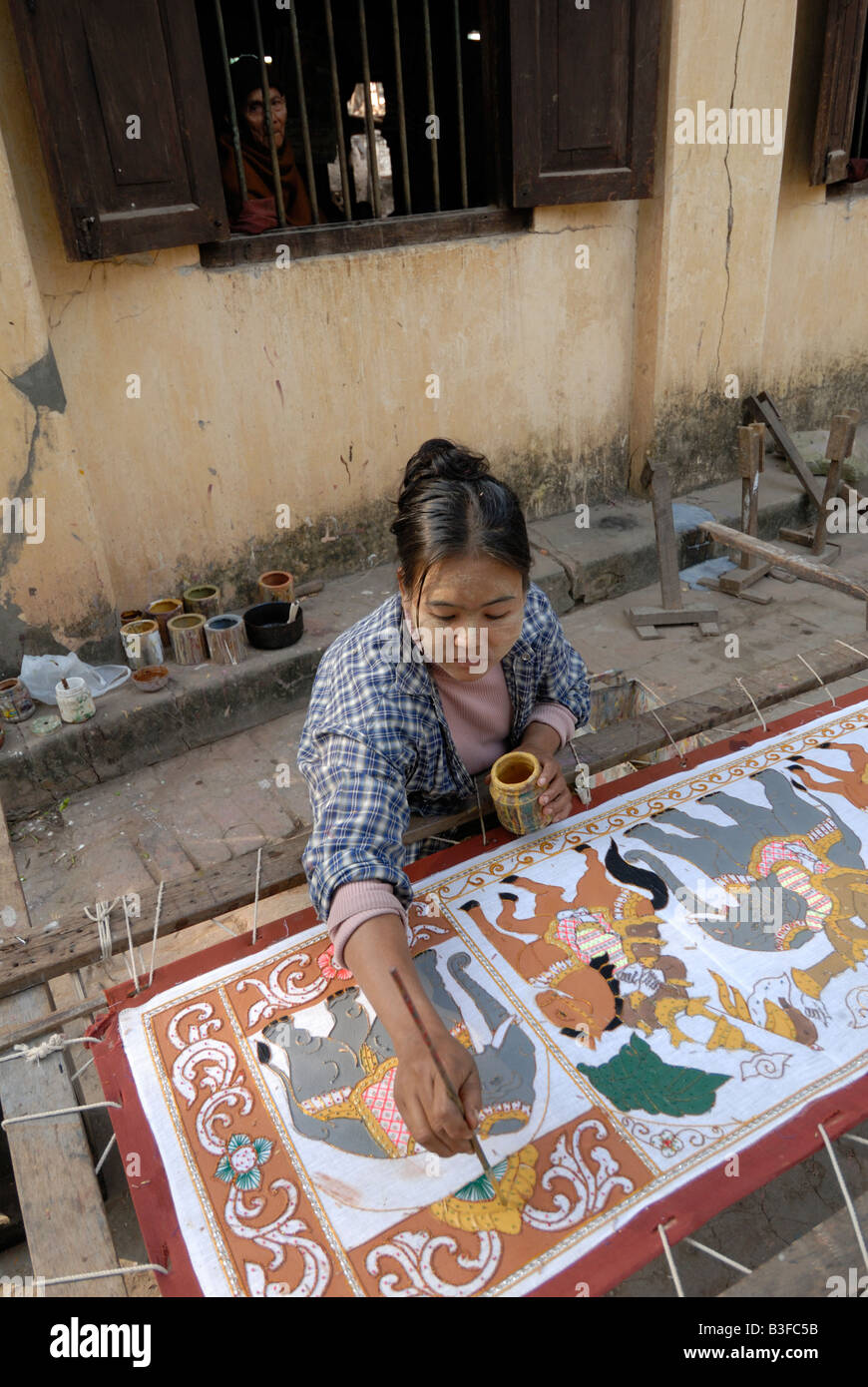 burmese painter working on the wall tapestry (kalagas) of myth theme ...