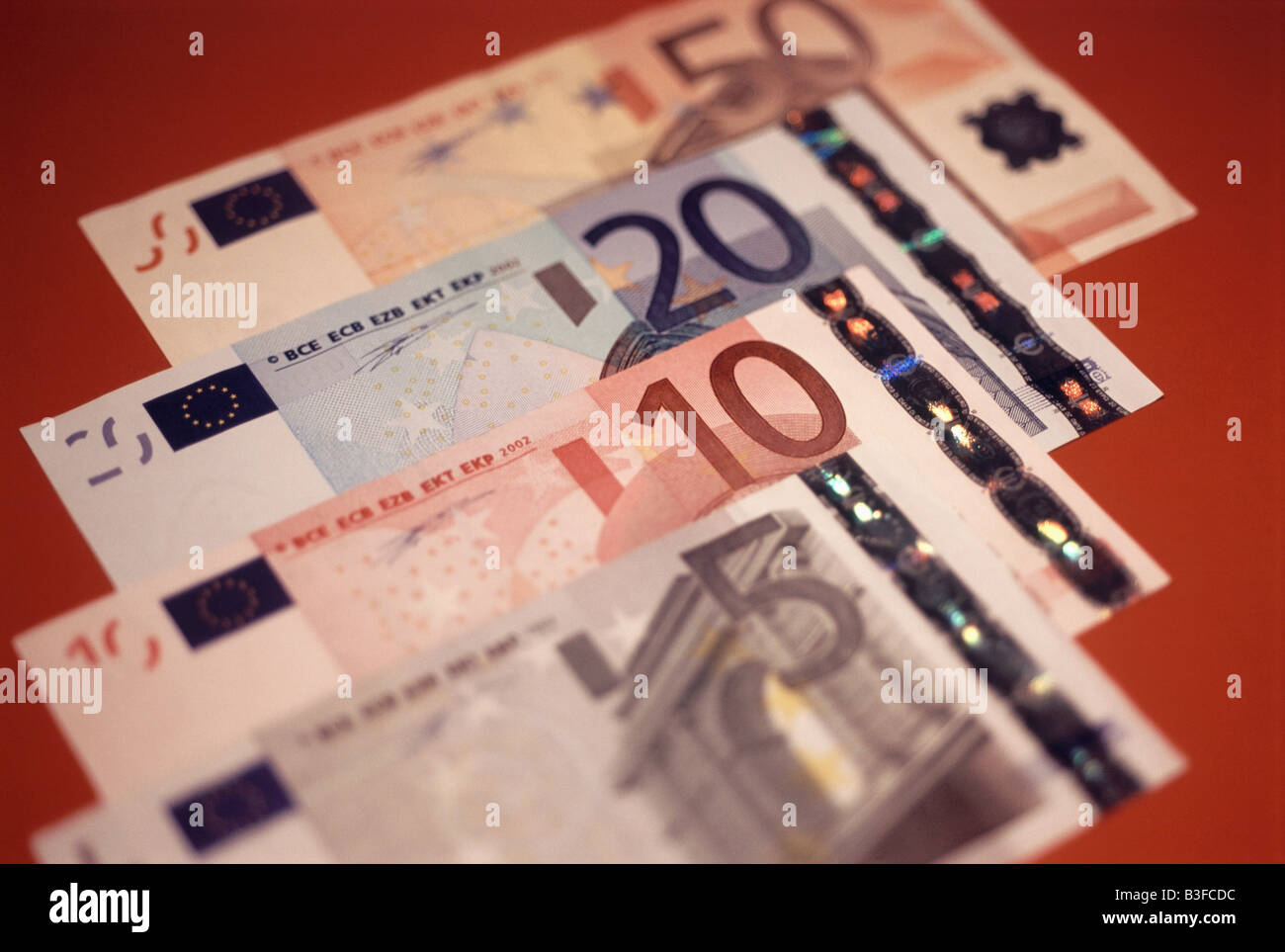 four european bank notes on a red background Stock Photo - Alamy