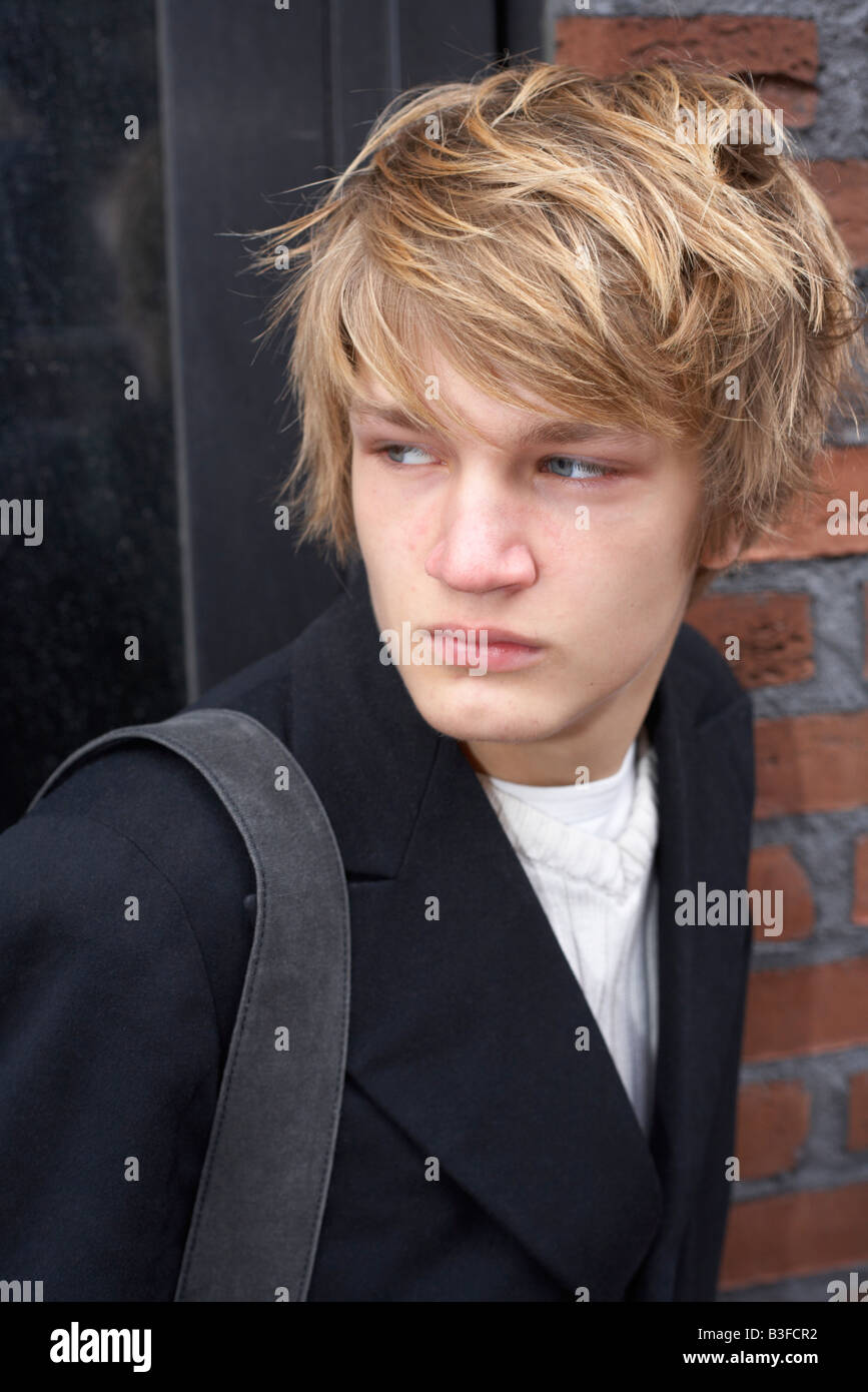 Teenage boy looking over shoulder outside building Stock Photo - Alamy