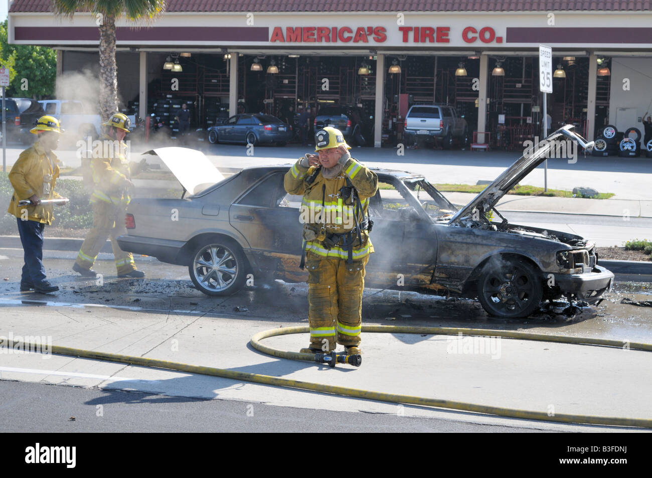 Firefighters evaluating wreckage from burning Mercedes Stock Photo - Alamy