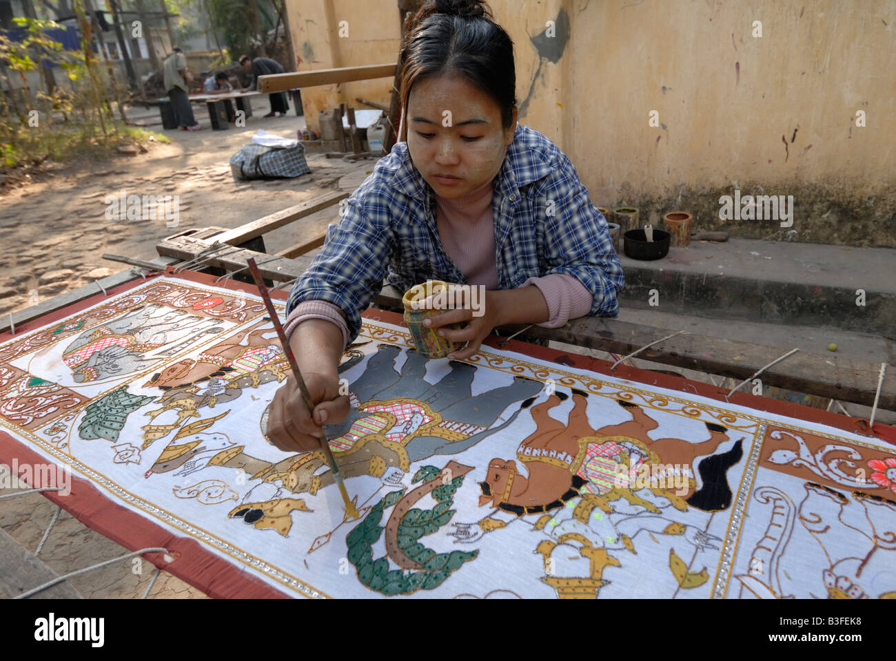burmese painter working on the wall tapestry (kalagas) of myth theme ...