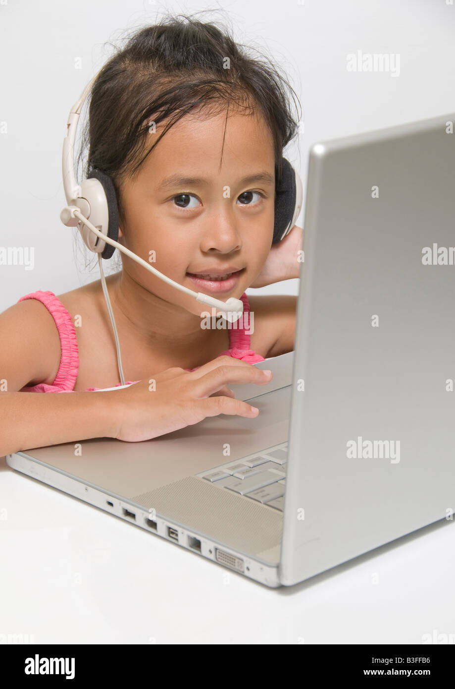 Young Asian child with computer and headset Stock Photo - Alamy