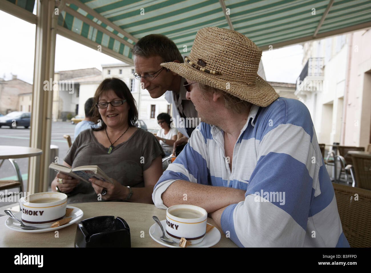 Two tourists using a foreign language guide book in a french cafe Stock ...
