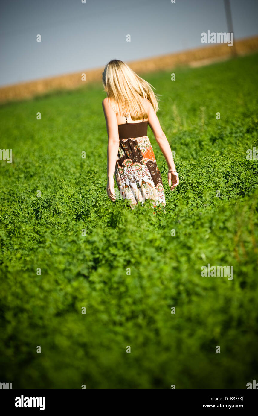 Young girl wades through a green field Stock Photo - Alamy