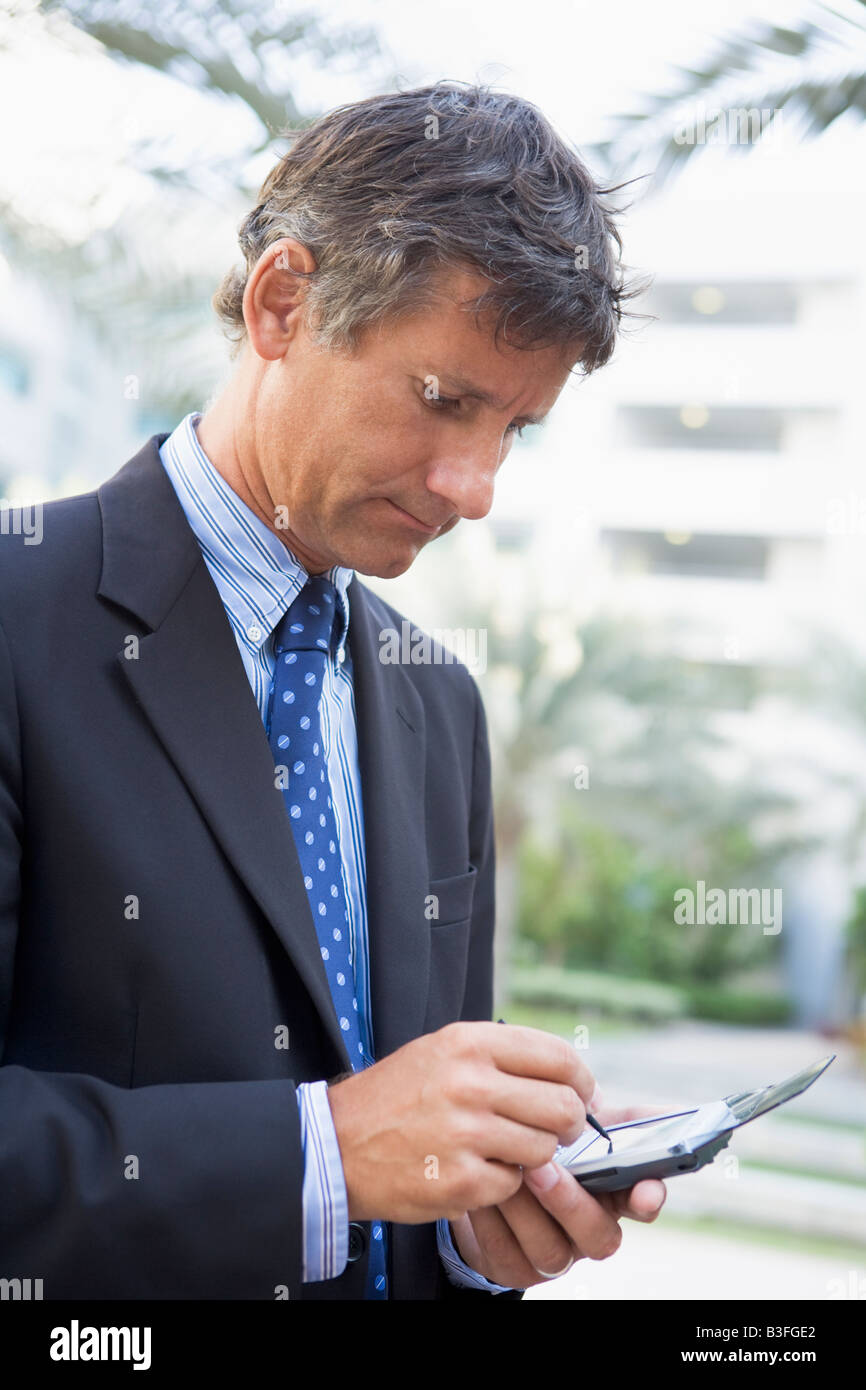 Businessman outdoors using personal digital assistant Stock Photo - Alamy
