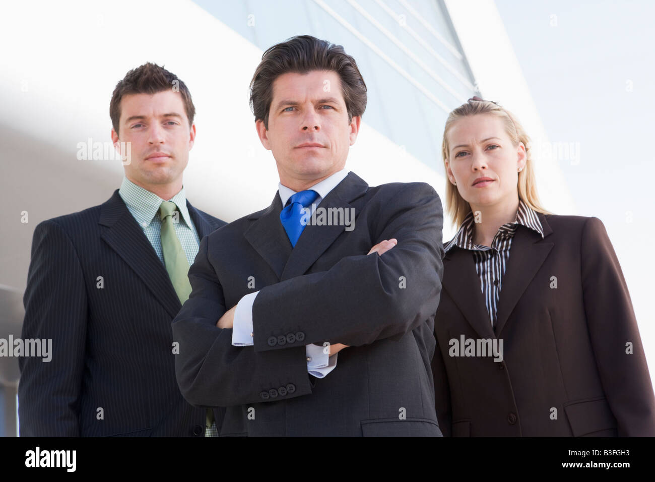 Three businesspeople standing outdoors by building Stock Photo - Alamy