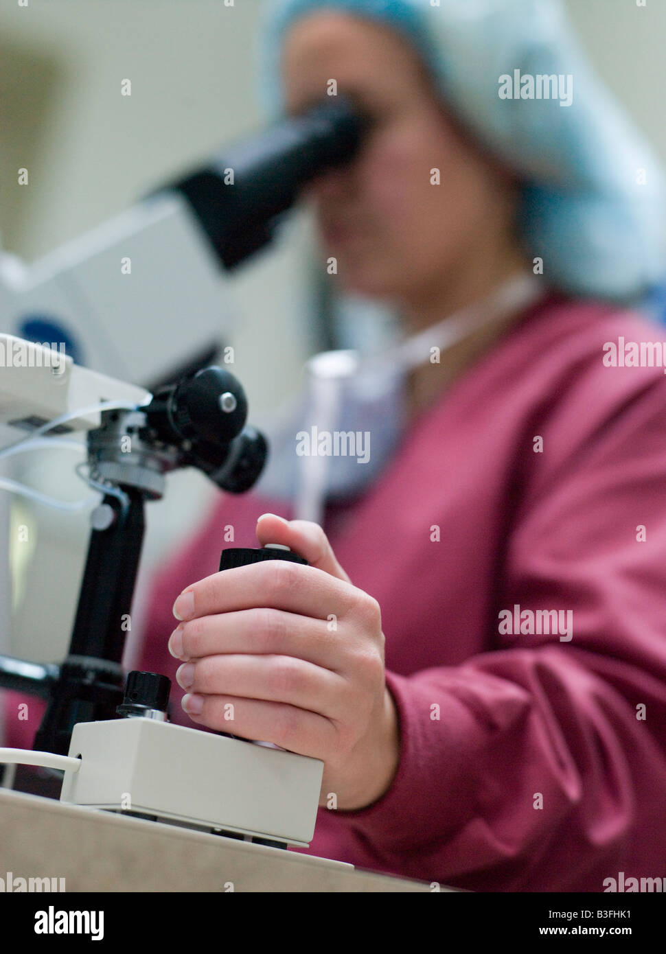 Embryologist with microscope performing an intra cytoplasmic sperm ...