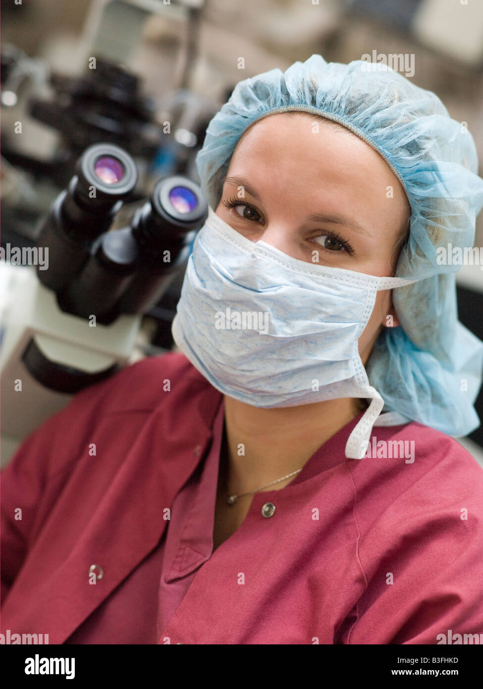 Embryologist sitting by microscope with mask on (selective focus Stock ...