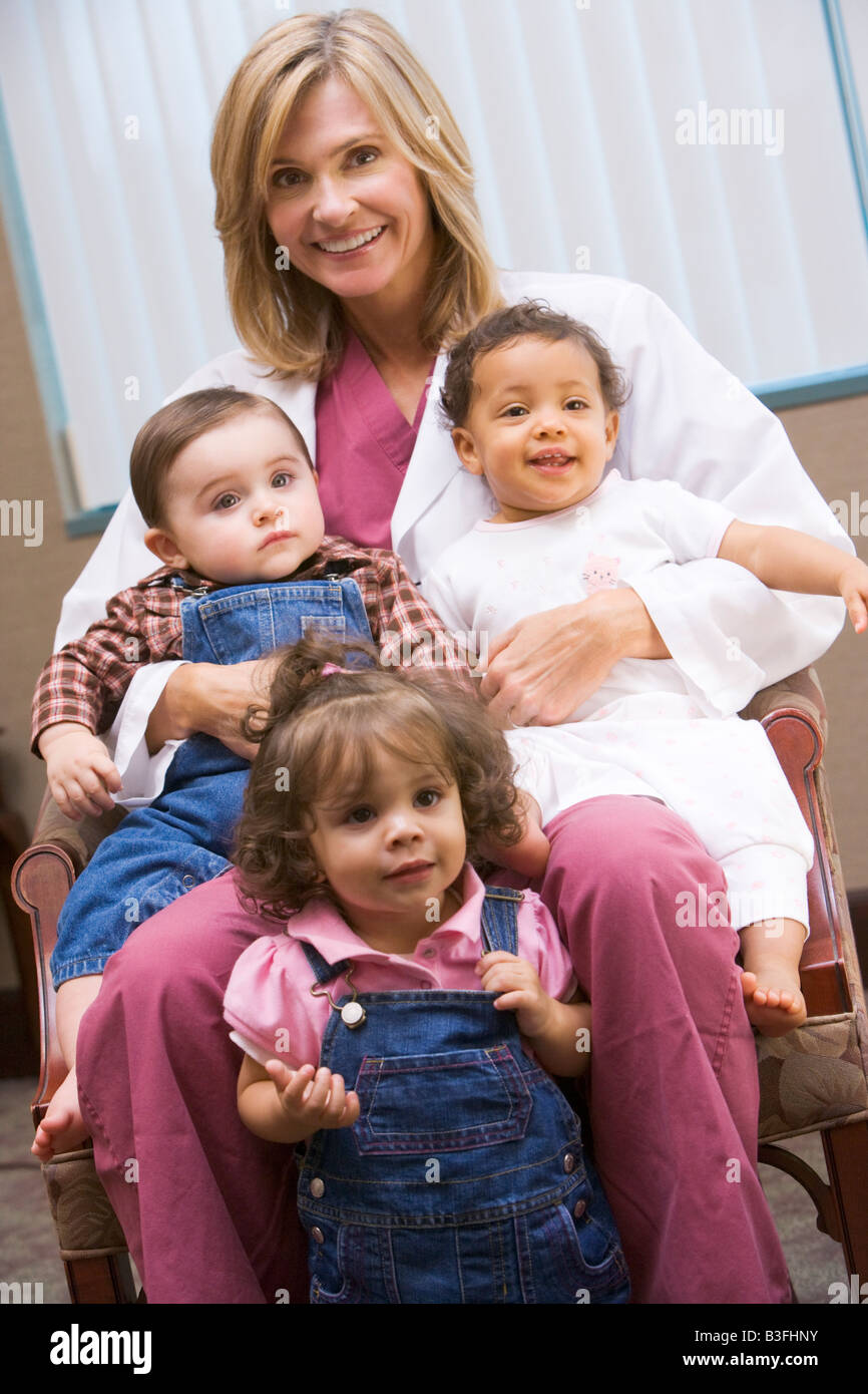 Doctor sitting with three IVF children smiling Stock Photo - Alamy