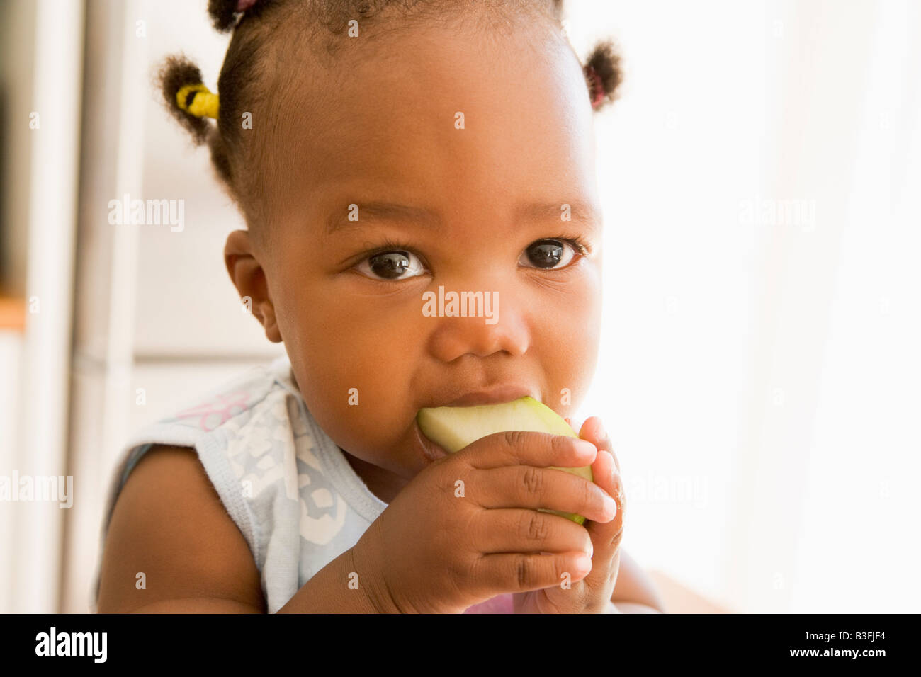 Young girl eating apple indoors Stock Photo - Alamy