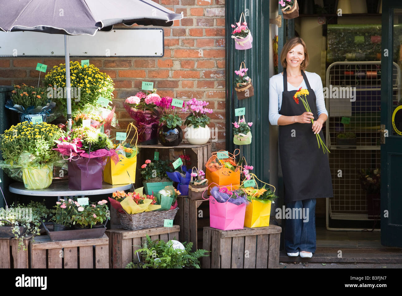 Woman working at flower shop smiling Stock Photo - Alamy