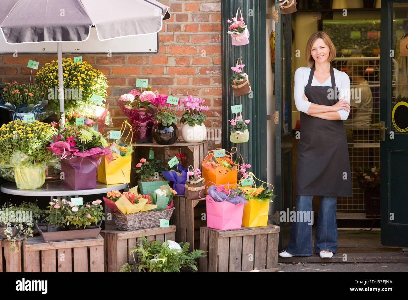 Woman working at flower shop smiling Stock Photo - Alamy