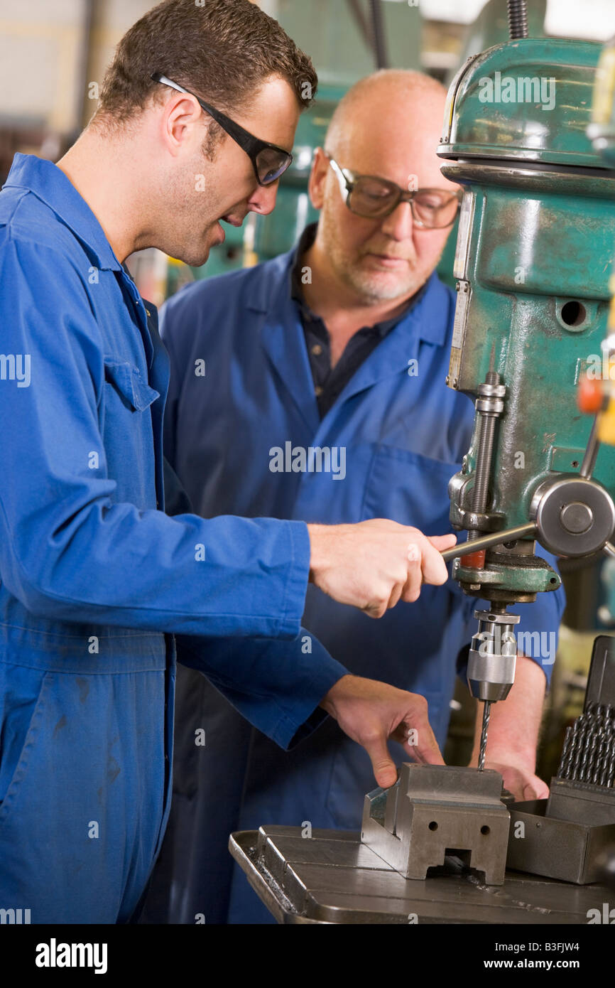 Two machinists working on machine Stock Photo - Alamy
