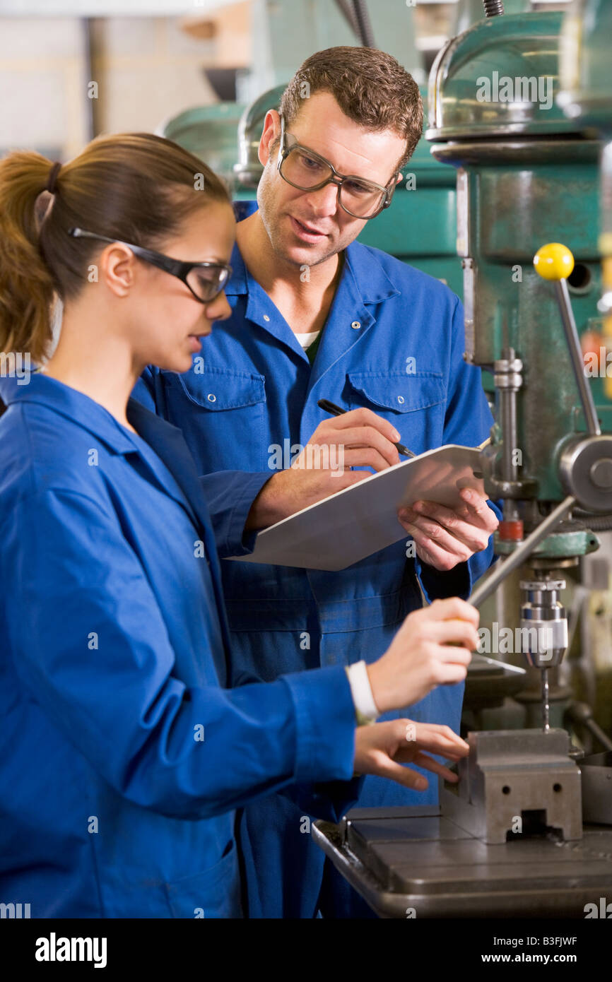 Two machinists working on machine Stock Photo - Alamy
