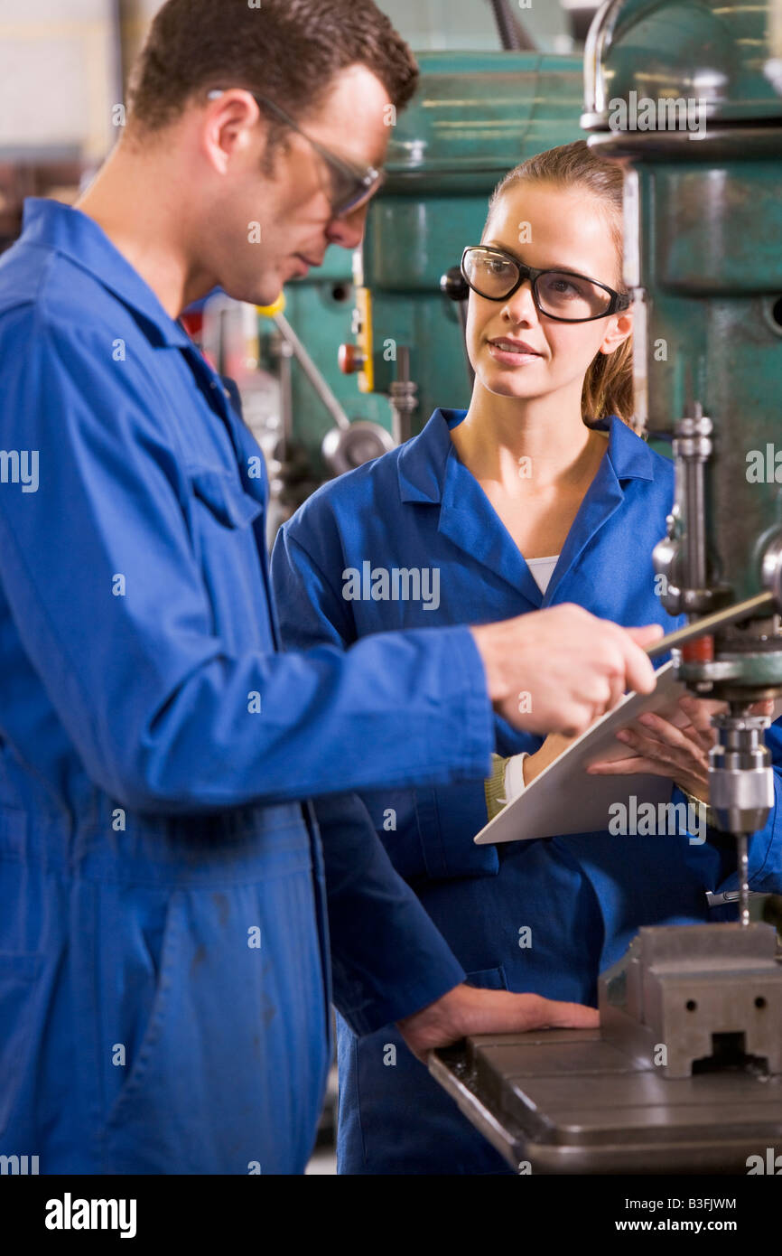 Two machinists working on machine Stock Photo - Alamy