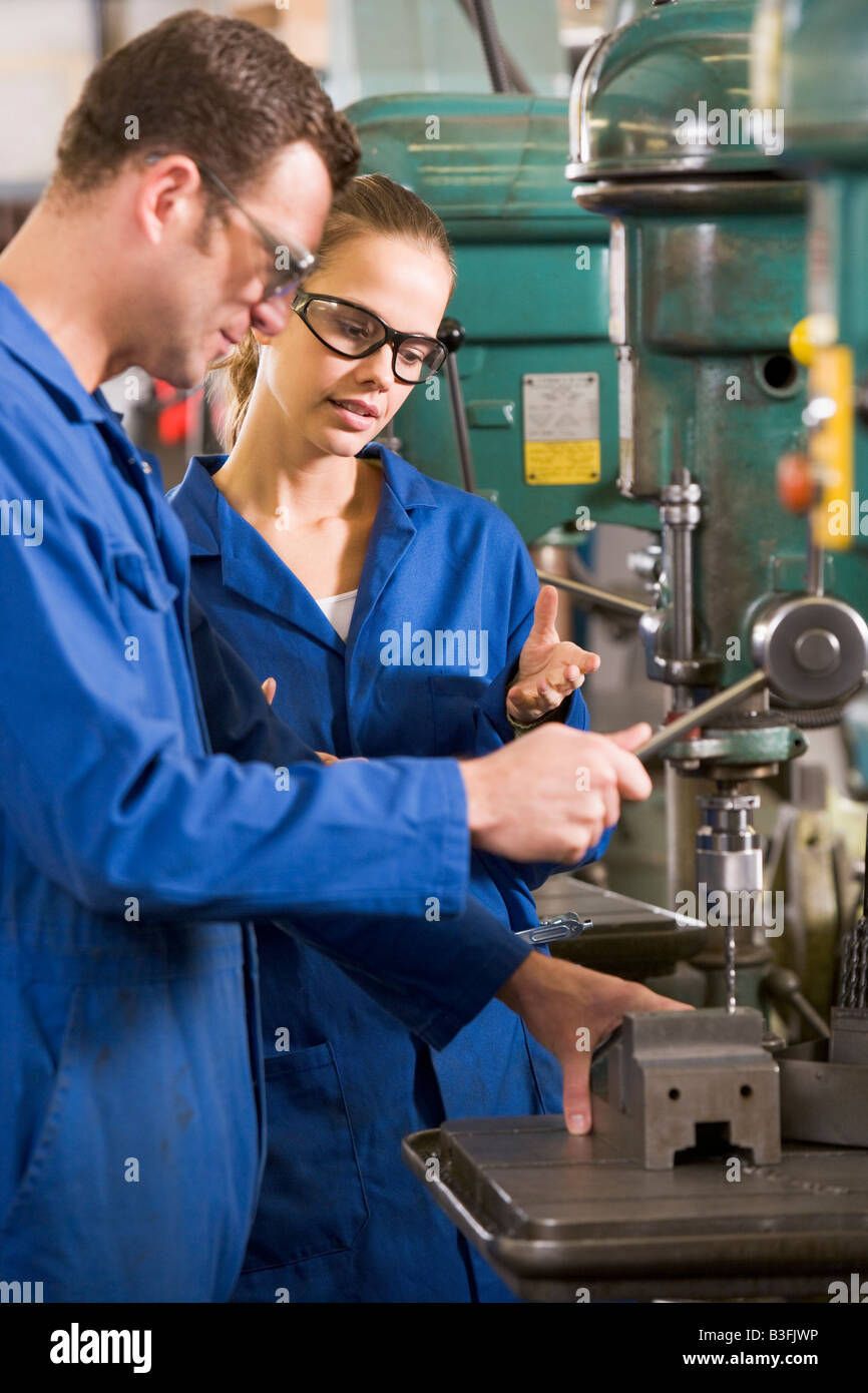 Two machinists working on machine Stock Photo - Alamy