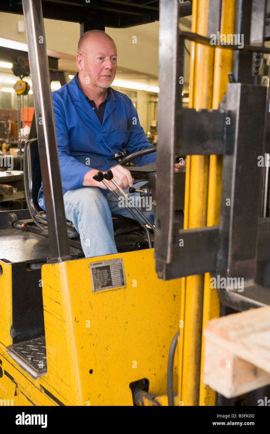 Warehouse worker in forklift Stock Photo - Alamy