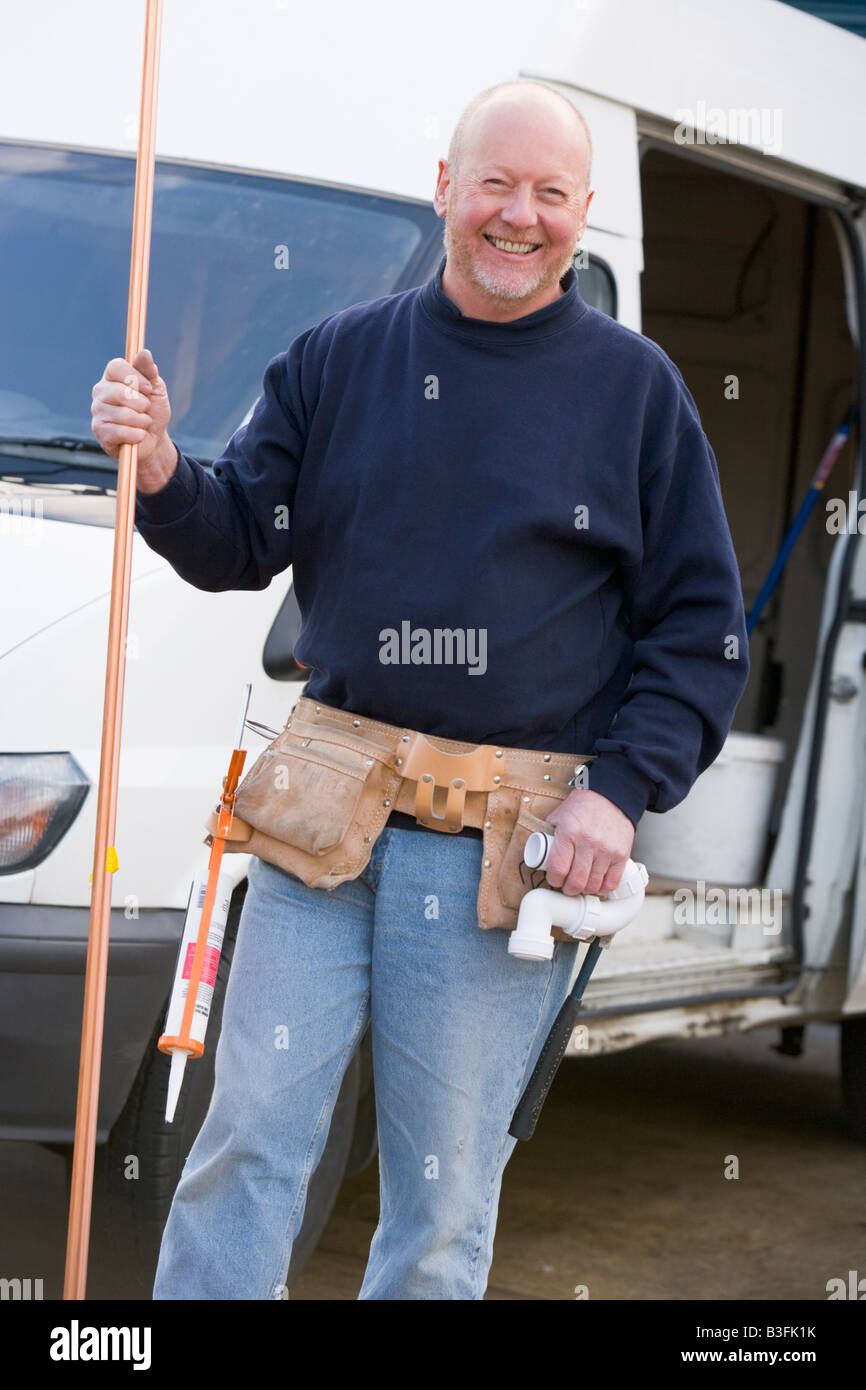 Plumber standing with van smiling Stock Photo - Alamy