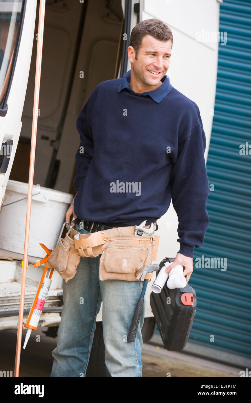 Plumber standing with van smiling Stock Photo - Alamy