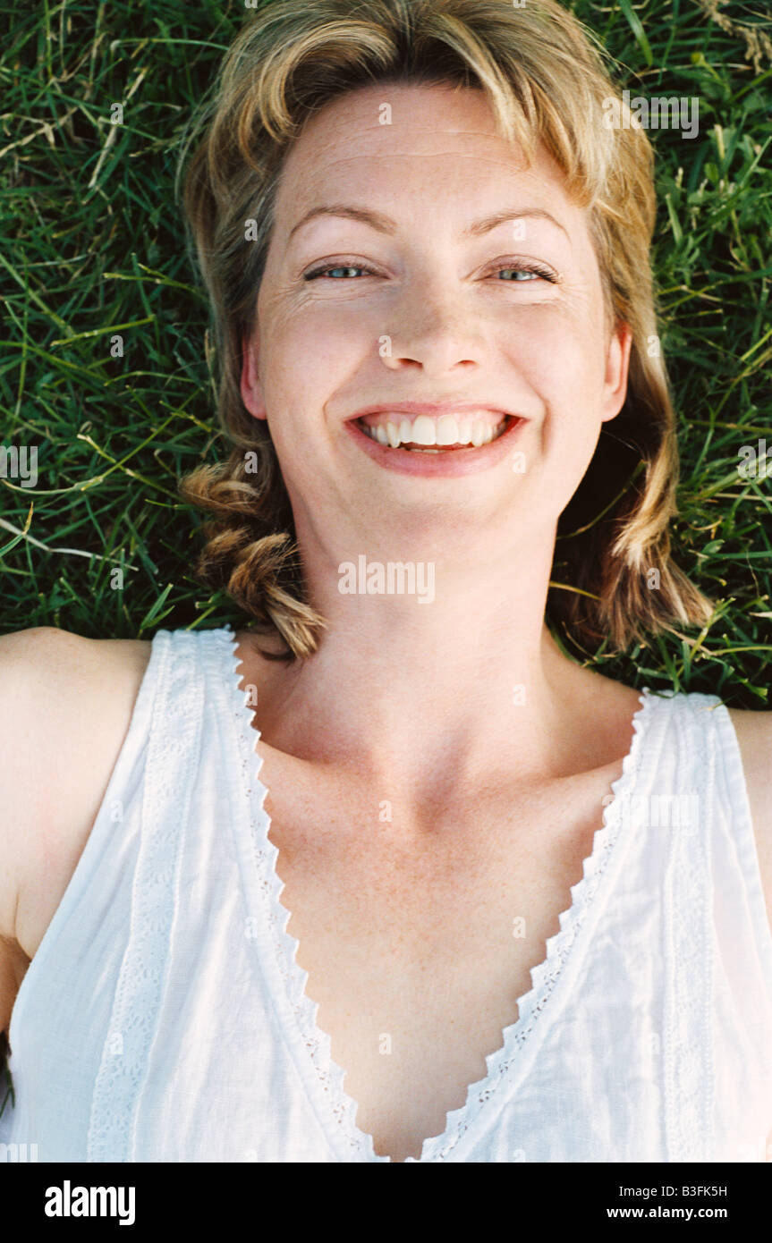 Woman lying outdoors smiling Stock Photo - Alamy