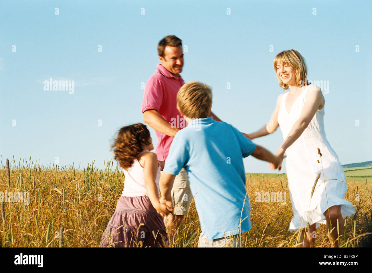 Family playing outdoors smiling Stock Photo - Alamy