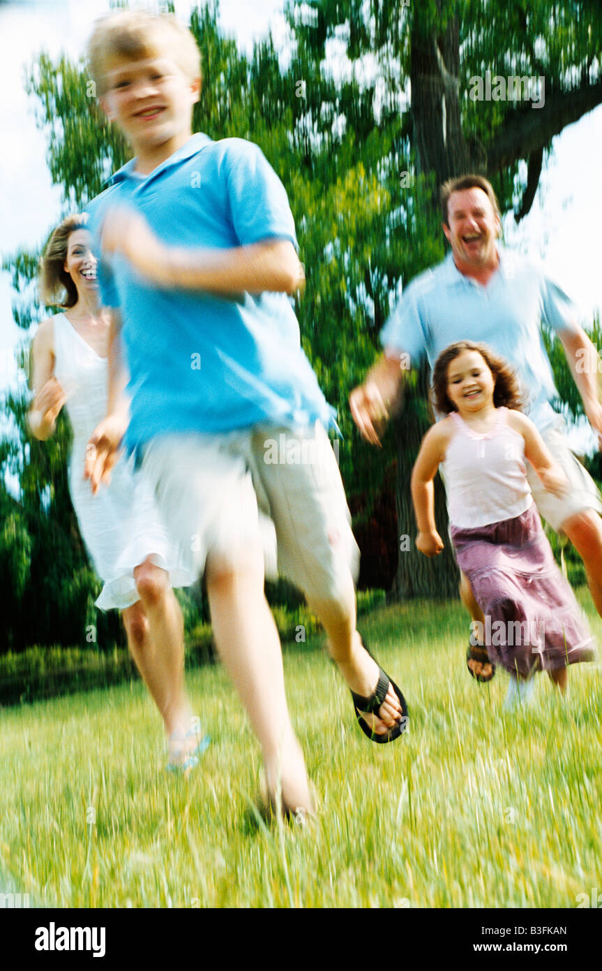 Family running outdoors smiling Stock Photo - Alamy