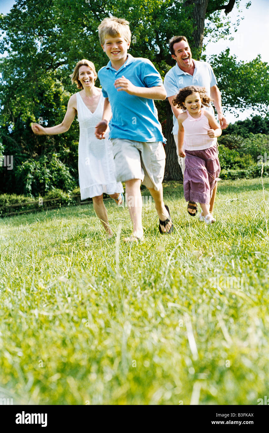 Family running outdoors smiling Stock Photo - Alamy