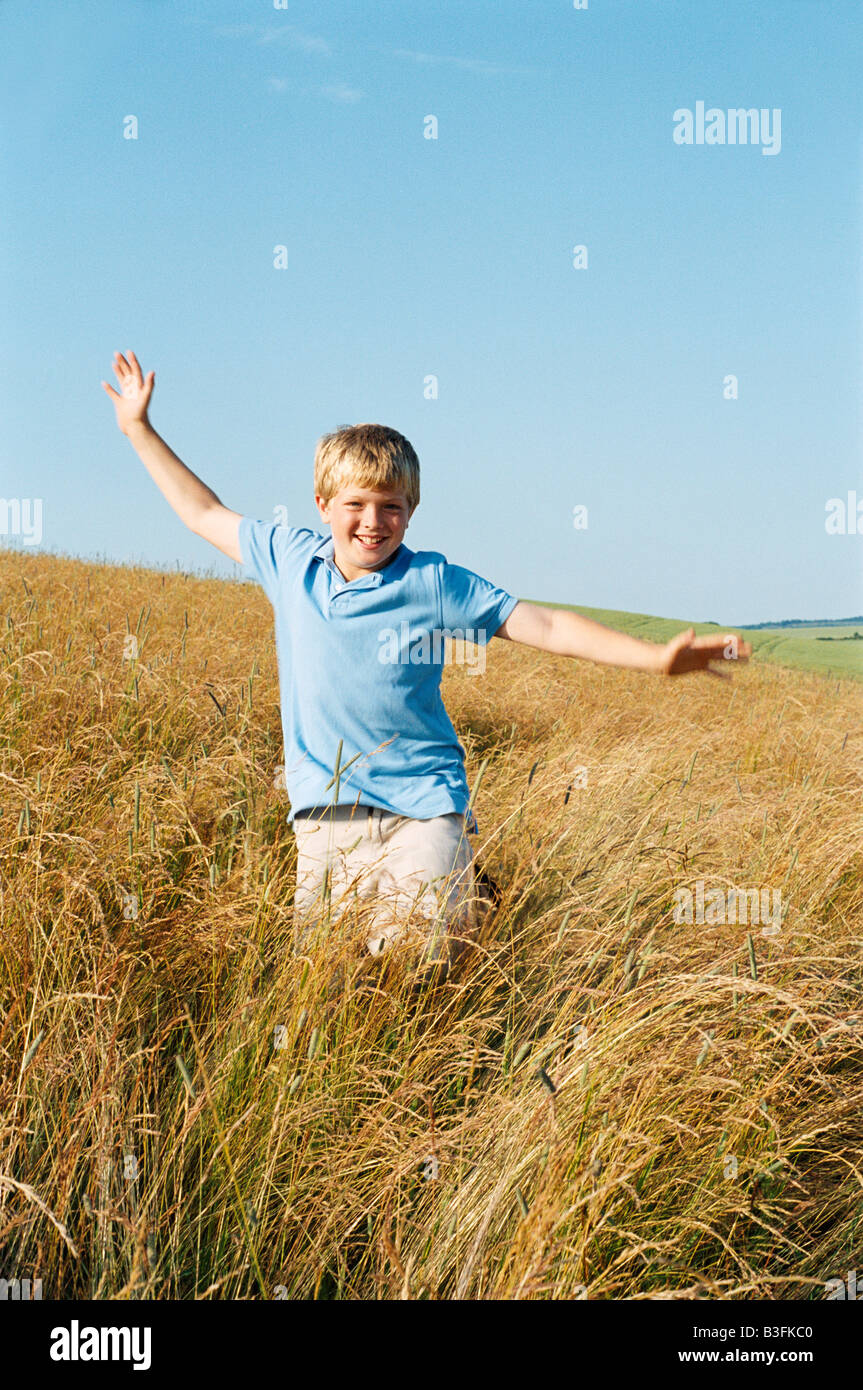 Young boy running outdoors smiling Stock Photo - Alamy