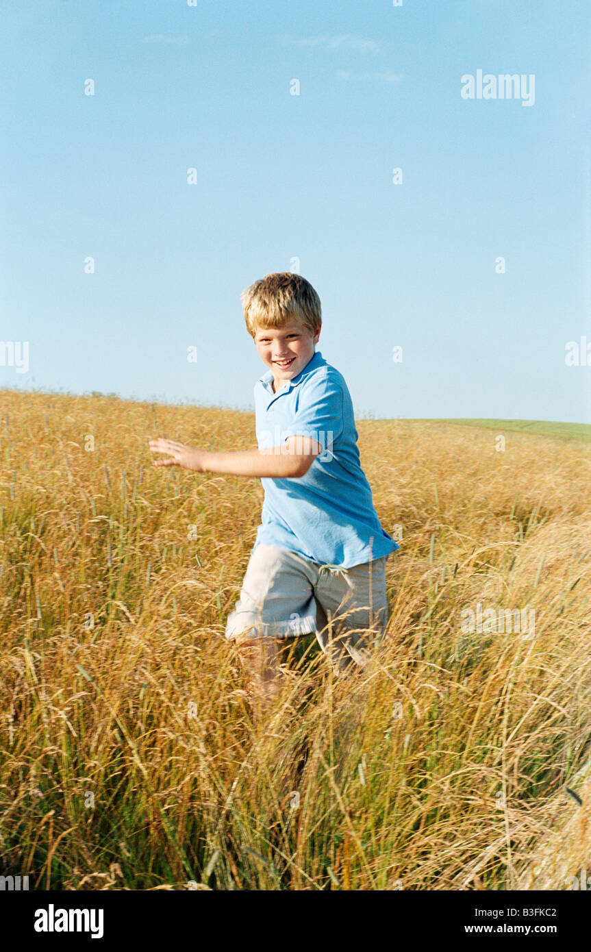 Young boy running outdoors smiling Stock Photo - Alamy