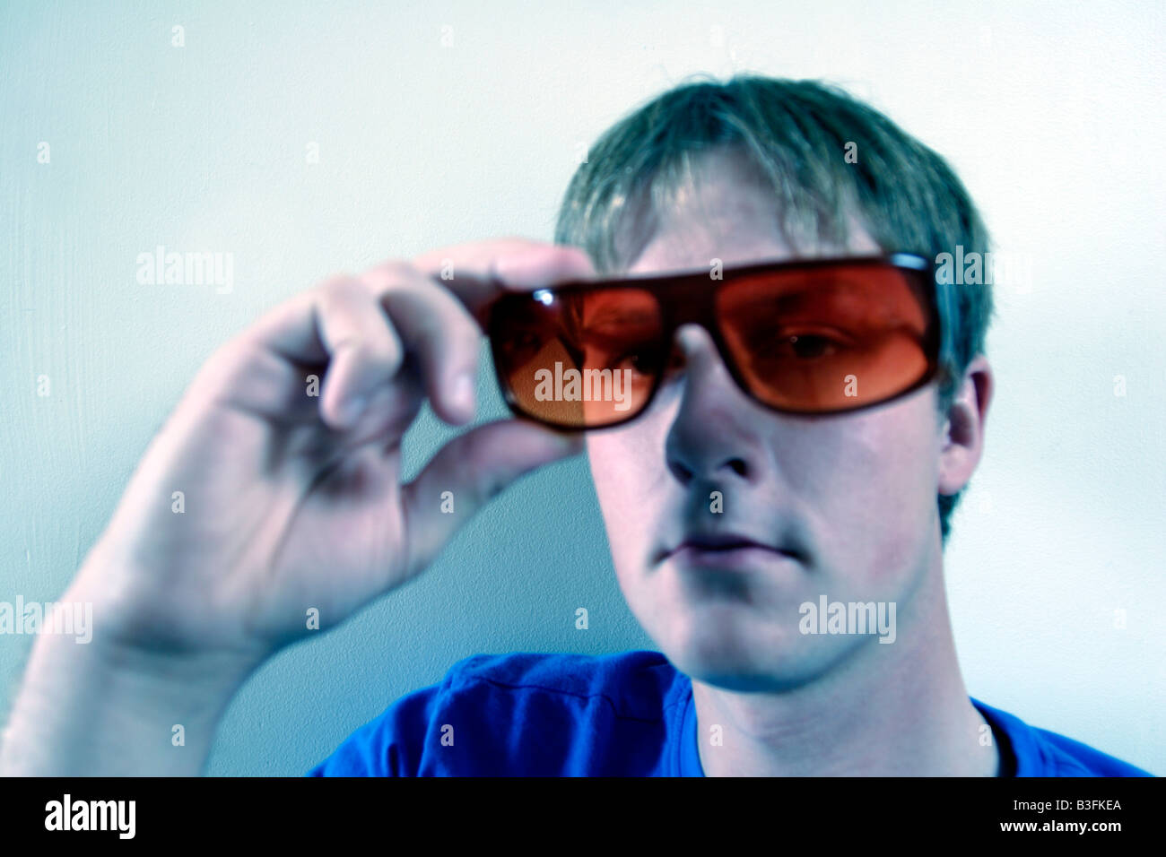 Out of focus person putting on sunglasses Stock Photo - Alamy
