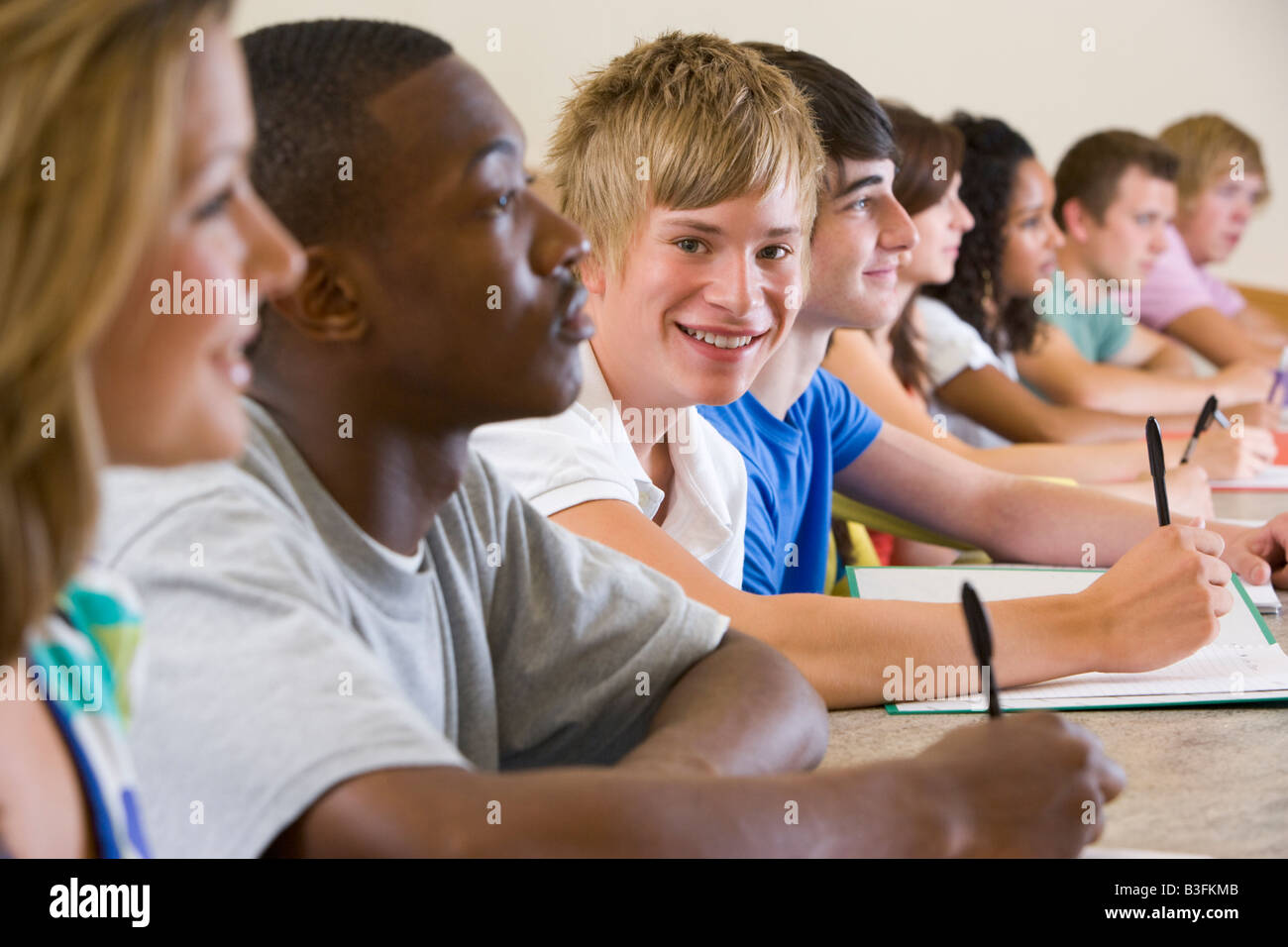 Students in class paying attention and taking notes (selective focus ...