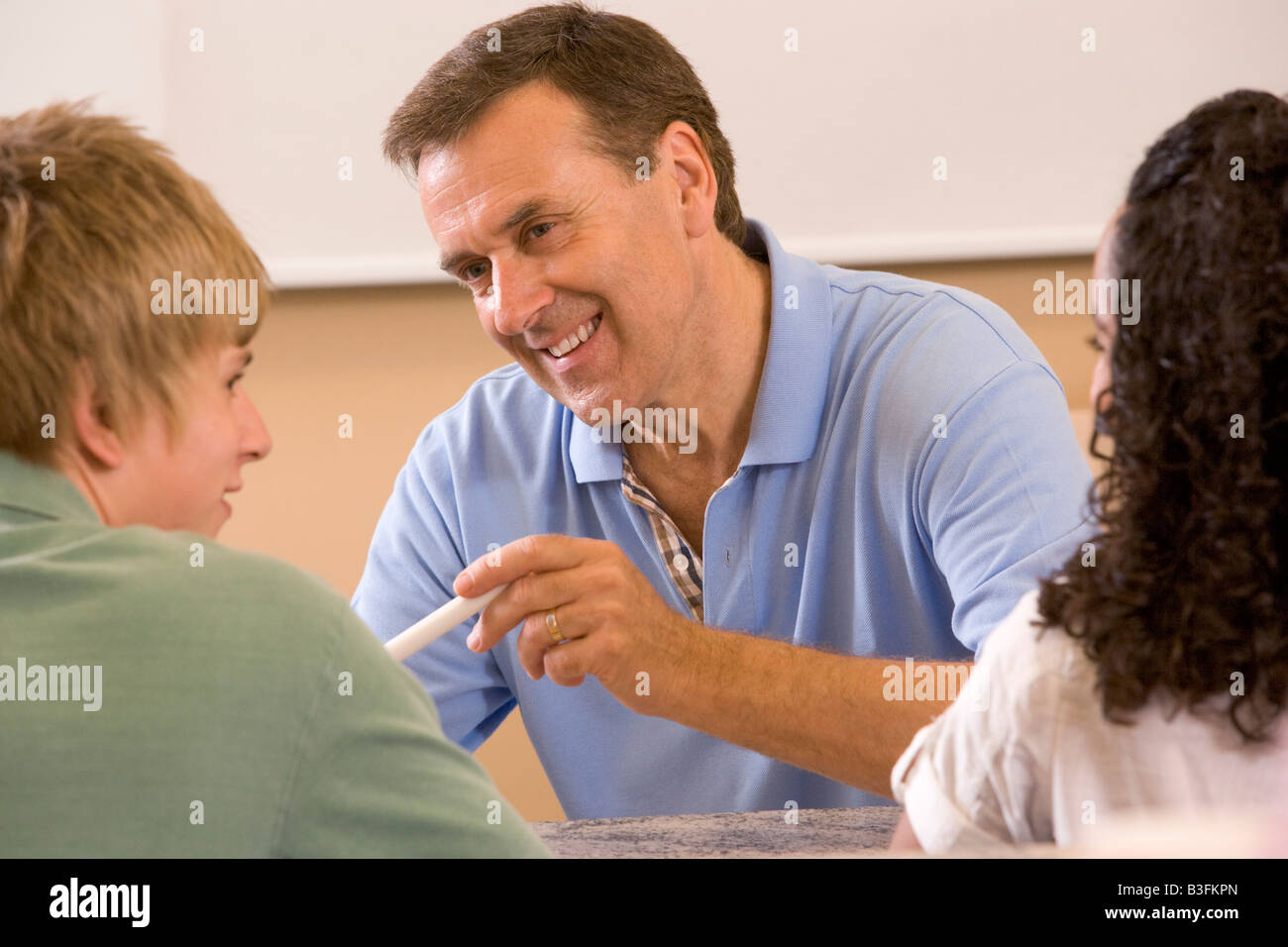 Teacher with two students in classroom Stock Photo - Alamy