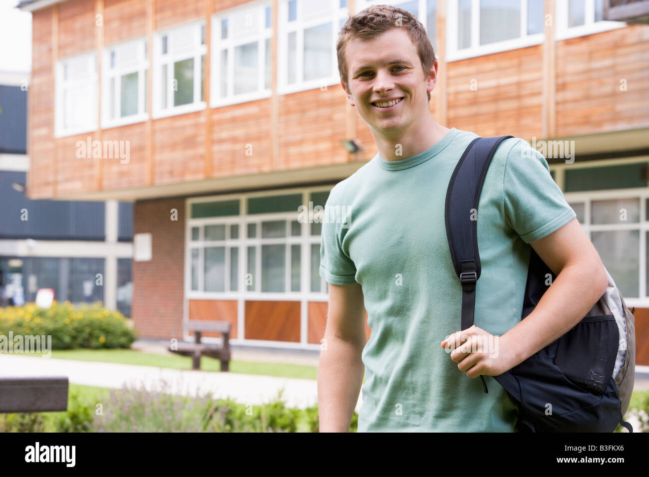 Student standing outdoors smiling Stock Photo - Alamy