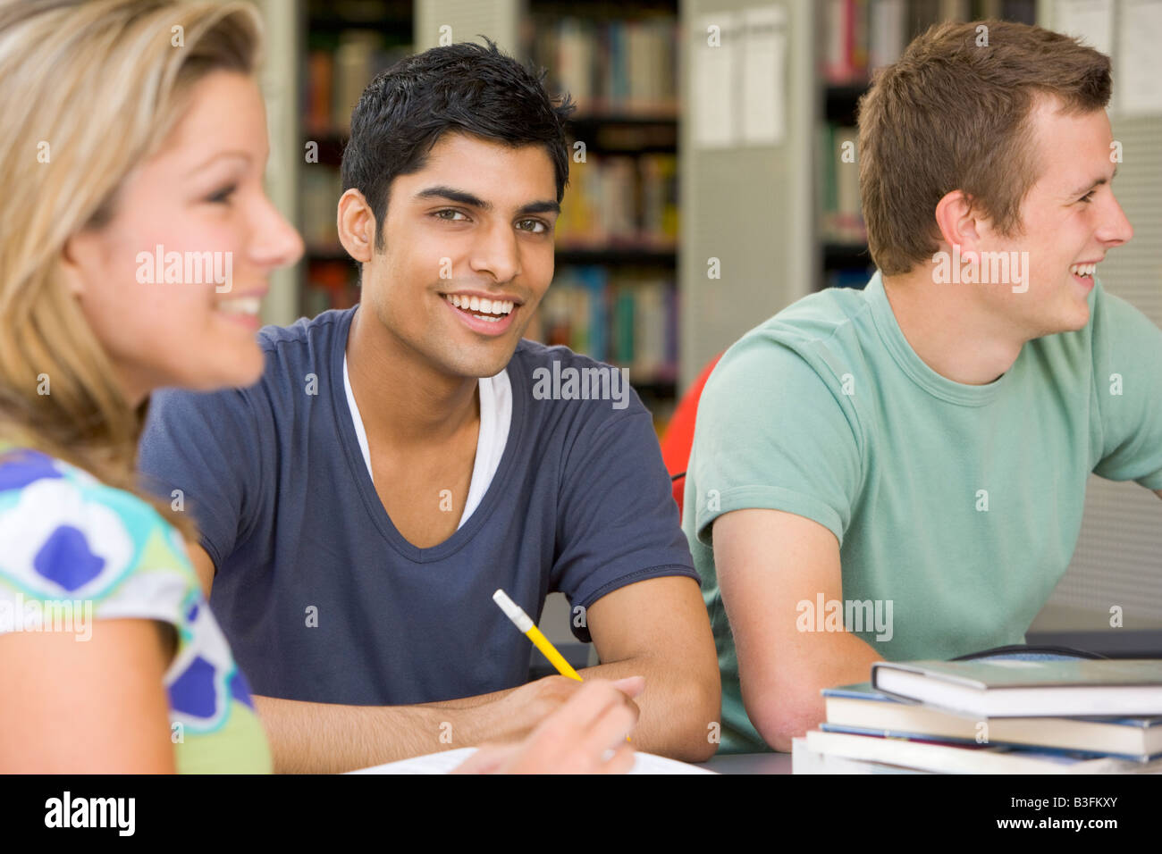 Three people in library studying (selective focus Stock Photo - Alamy