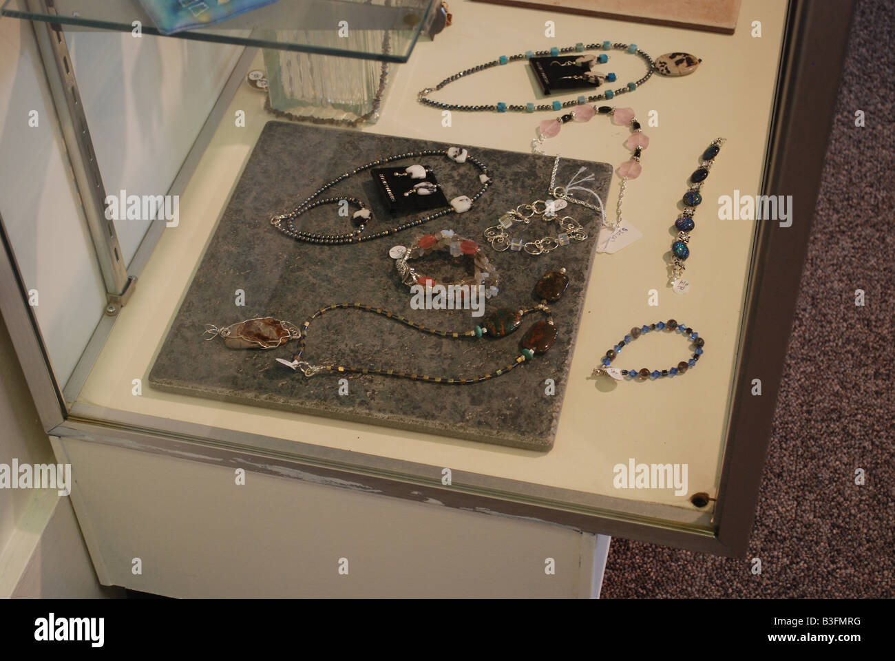 hand made jewelry on display in art gallery display case Stock Photo ...