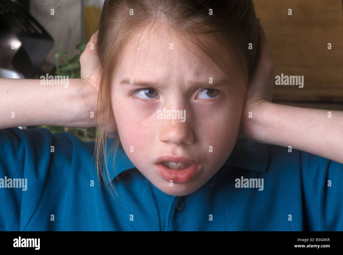 little girl with her hands over her ears Stock Photo - Alamy