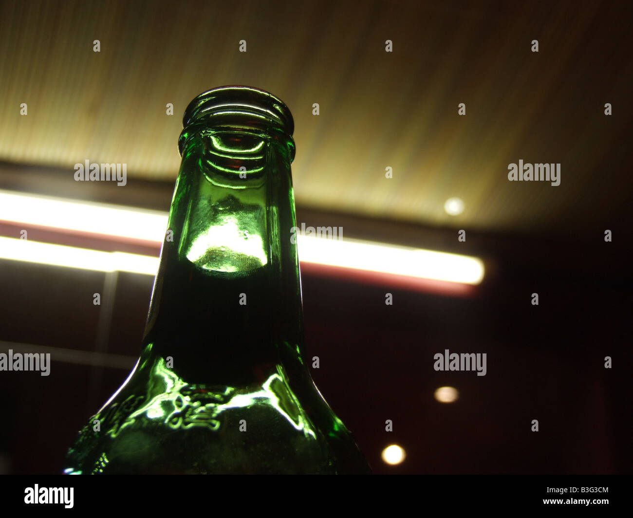 beer bottle detail inside dark room at night Stock Photo - Alamy